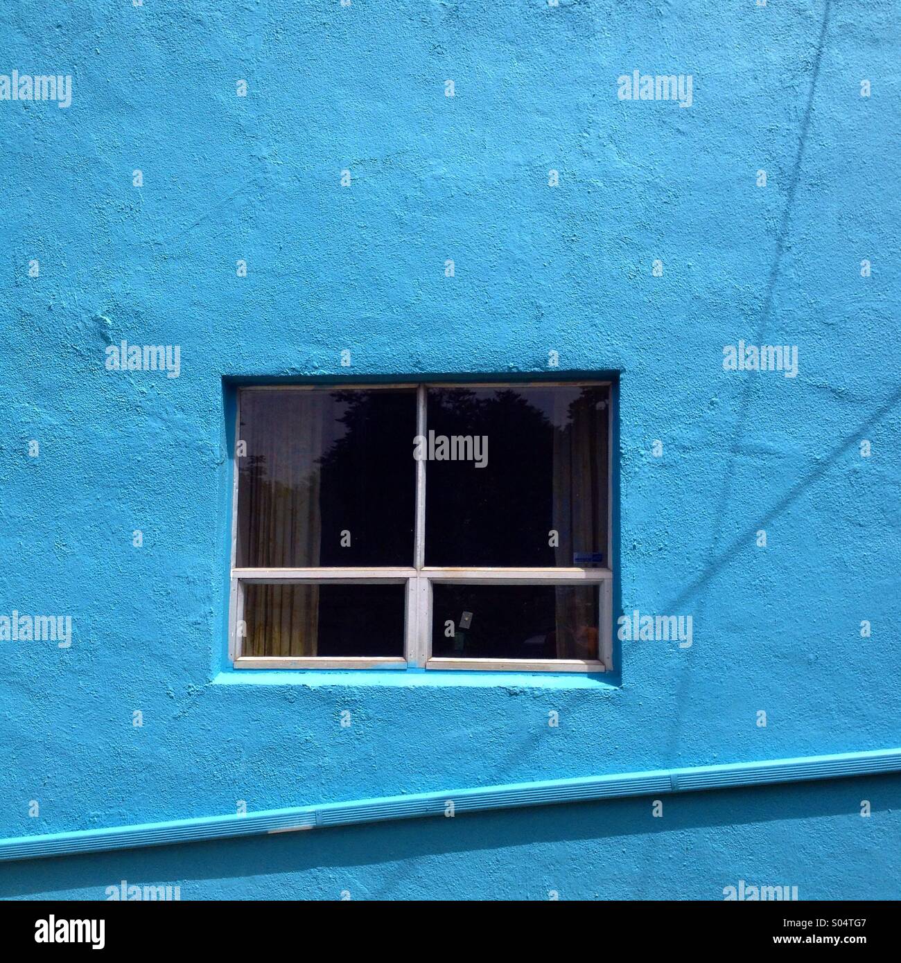 Bright blue wall with window Stock Photo - Alamy