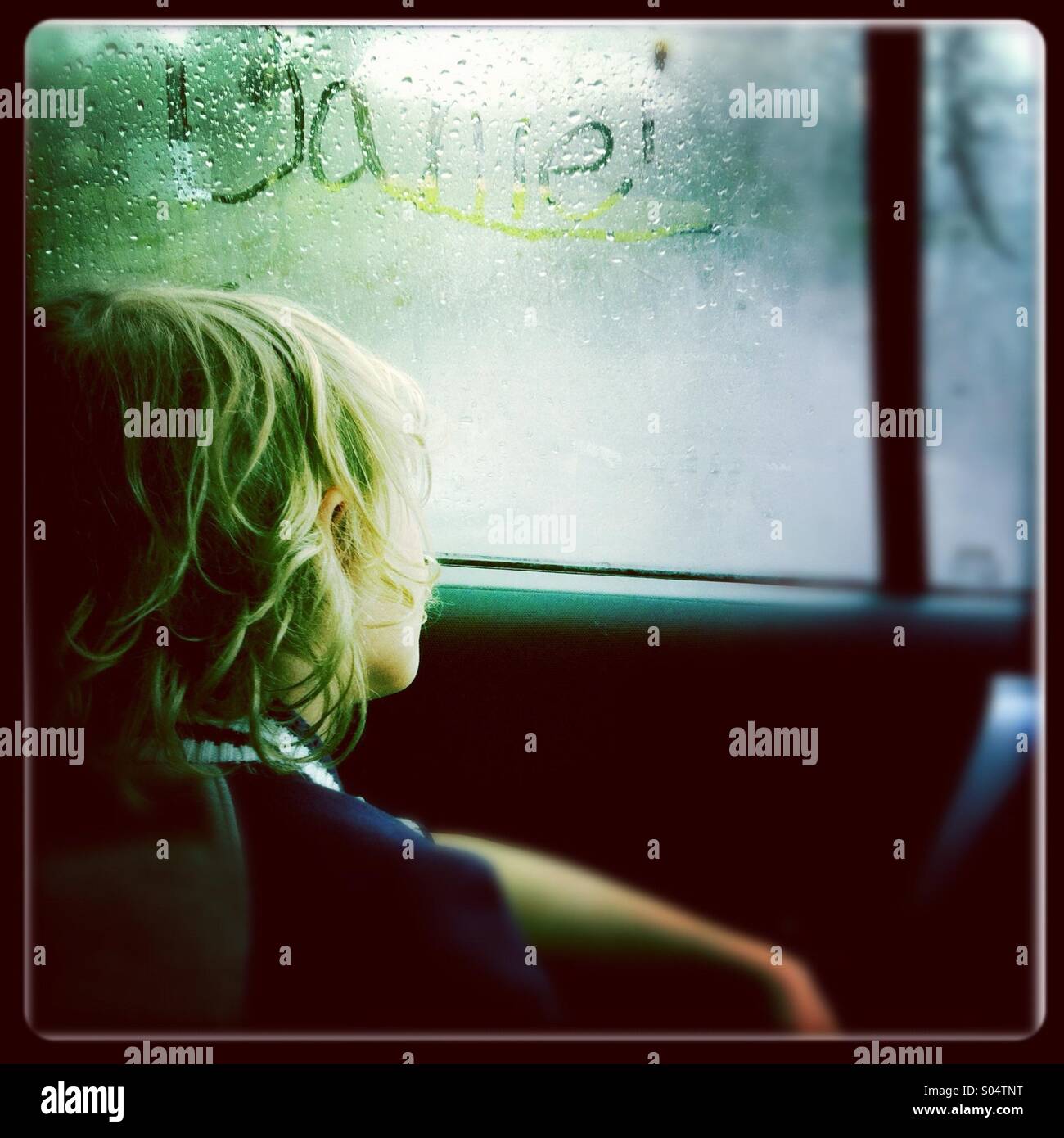 Boy looking out of window Stock Photo - Alamy