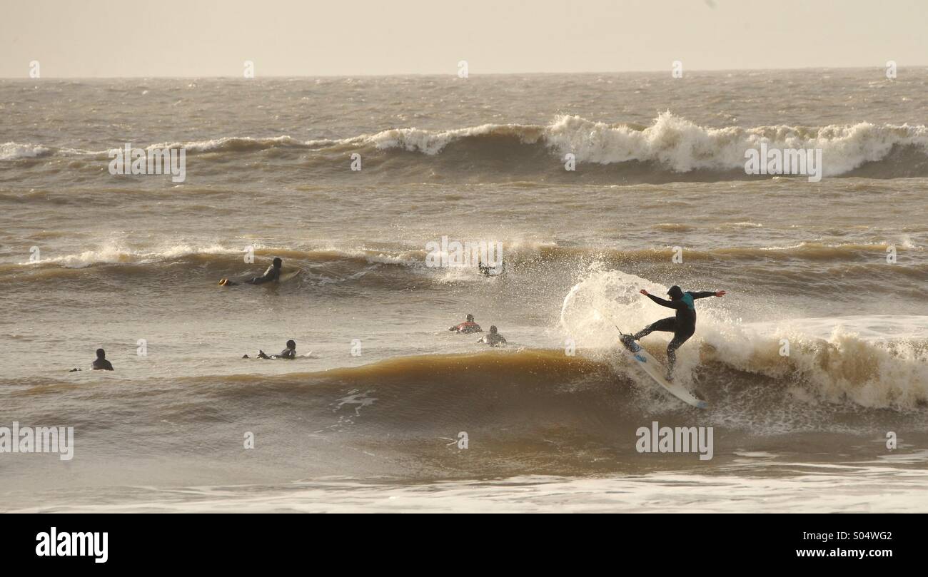 Surfer turns as many crowd for the next wave Stock Photo - Alamy