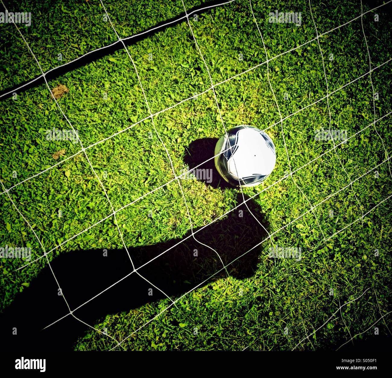 Shadow of foot kicking football Stock Photo - Alamy