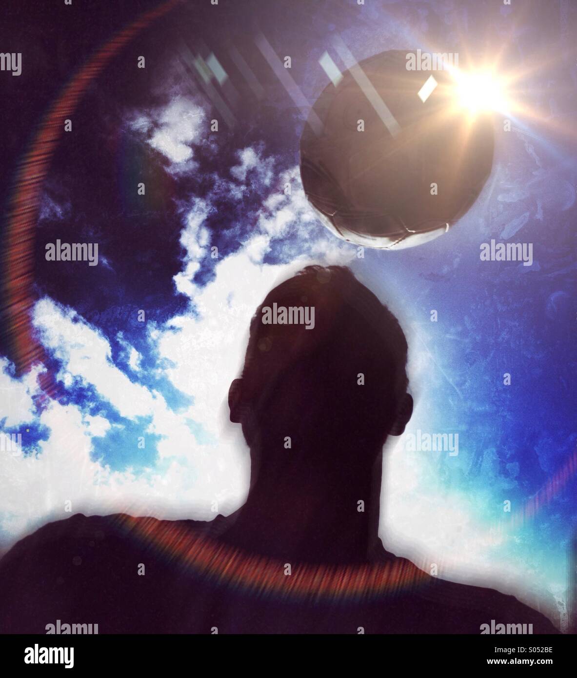 Man heading football in silhouette against sun Stock Photo - Alamy