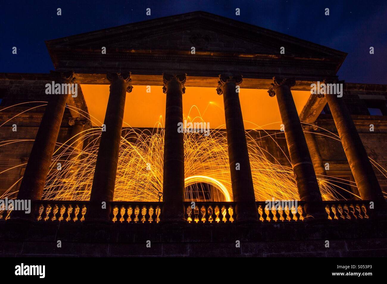 Long exposure of old ruined building at midnight lit up using wire wool ...