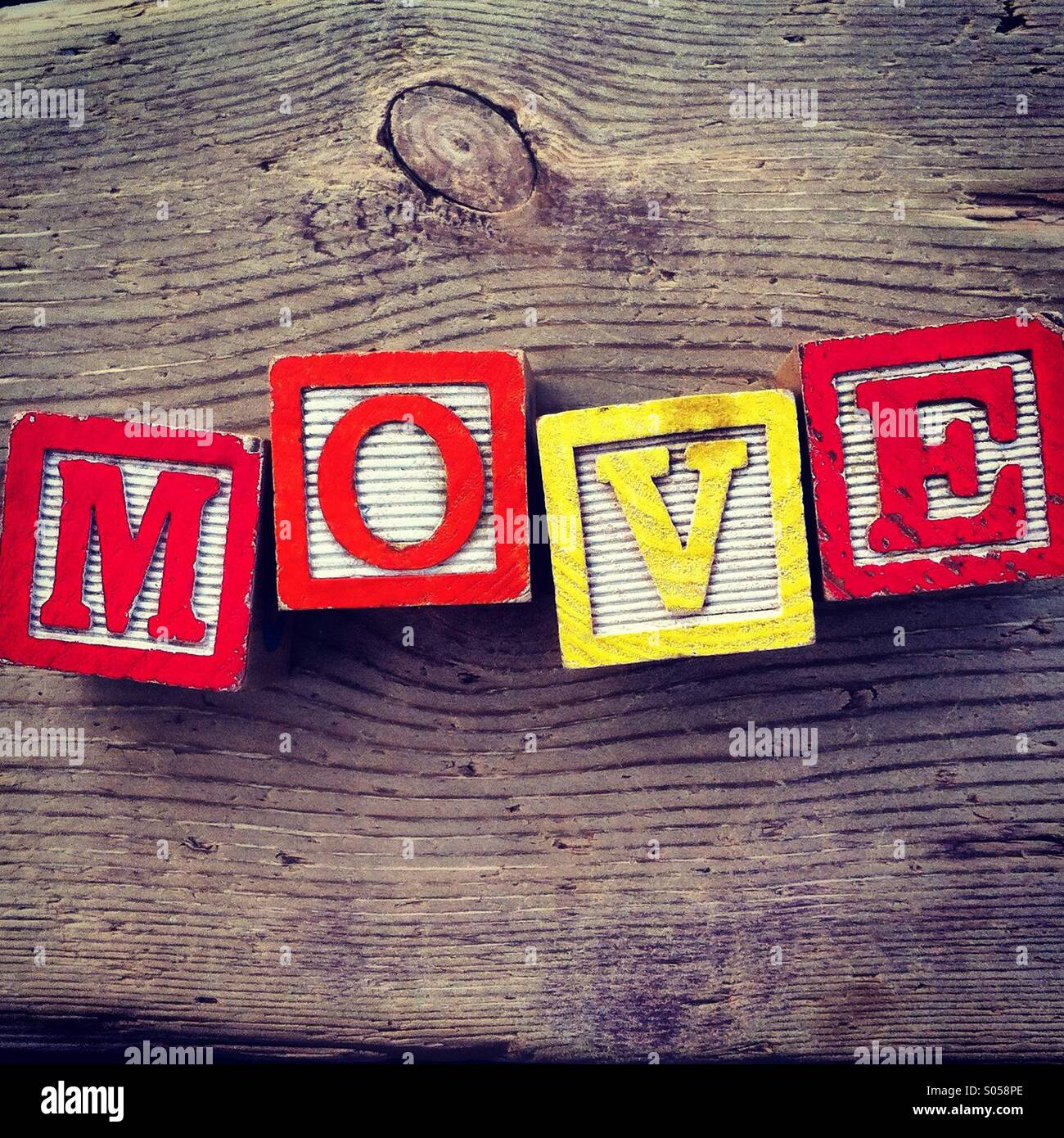 It's a photo of two wood cubes toy with letters that form the word MOVE ...