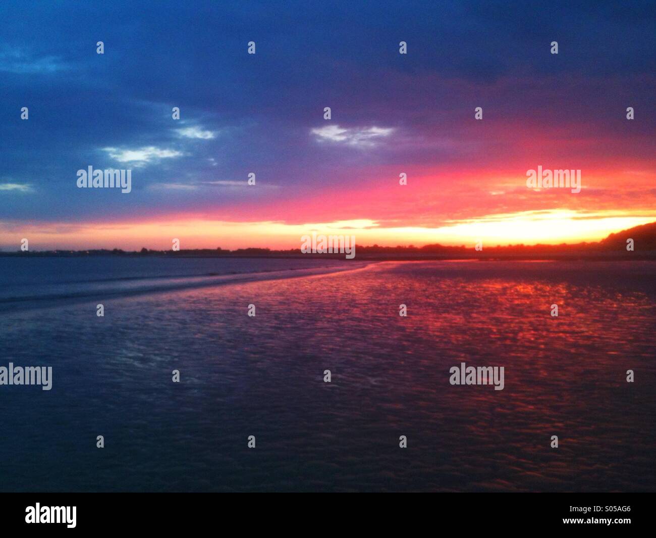 Colourful beach scene at dusk Stock Photo - Alamy