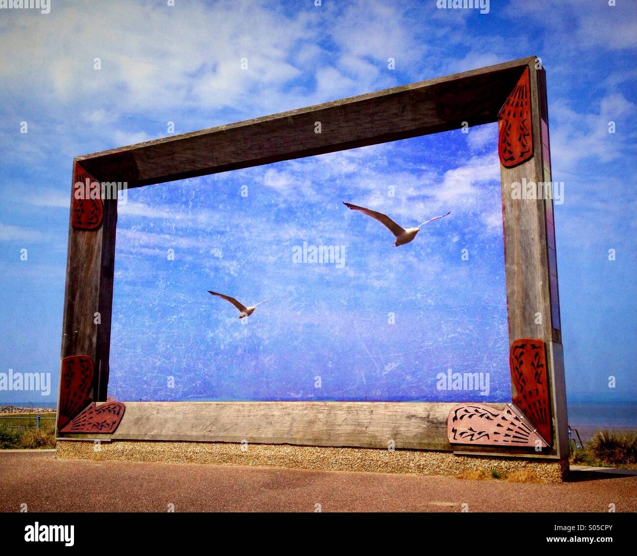Two seagulls flying through picture frame sculpture on Morecambe ...
