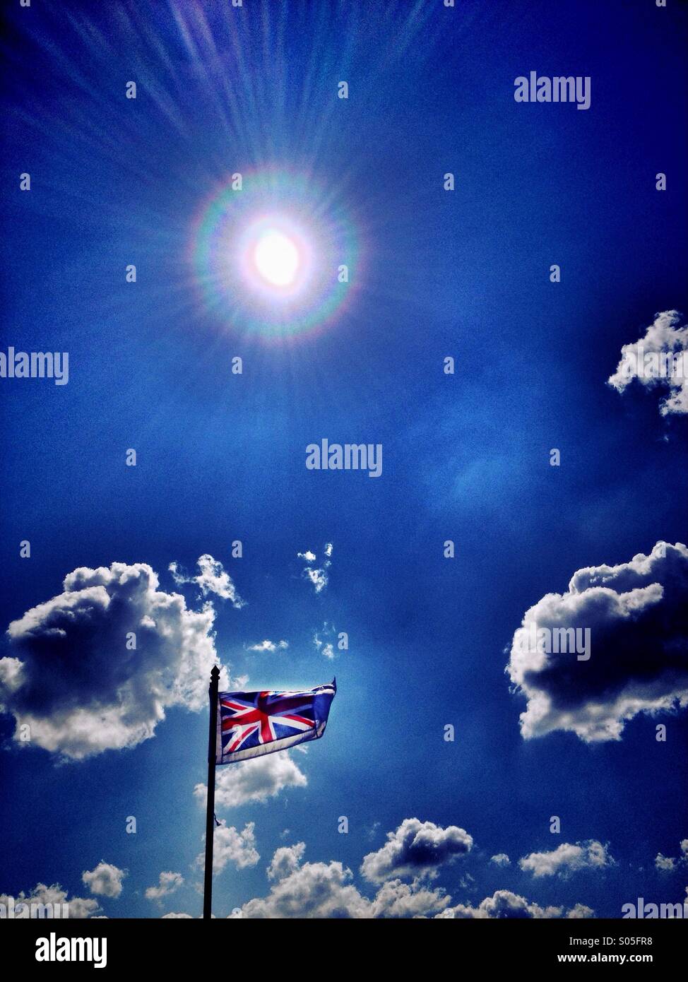 Union Jack flag clouds and full sun Stock Photo - Alamy