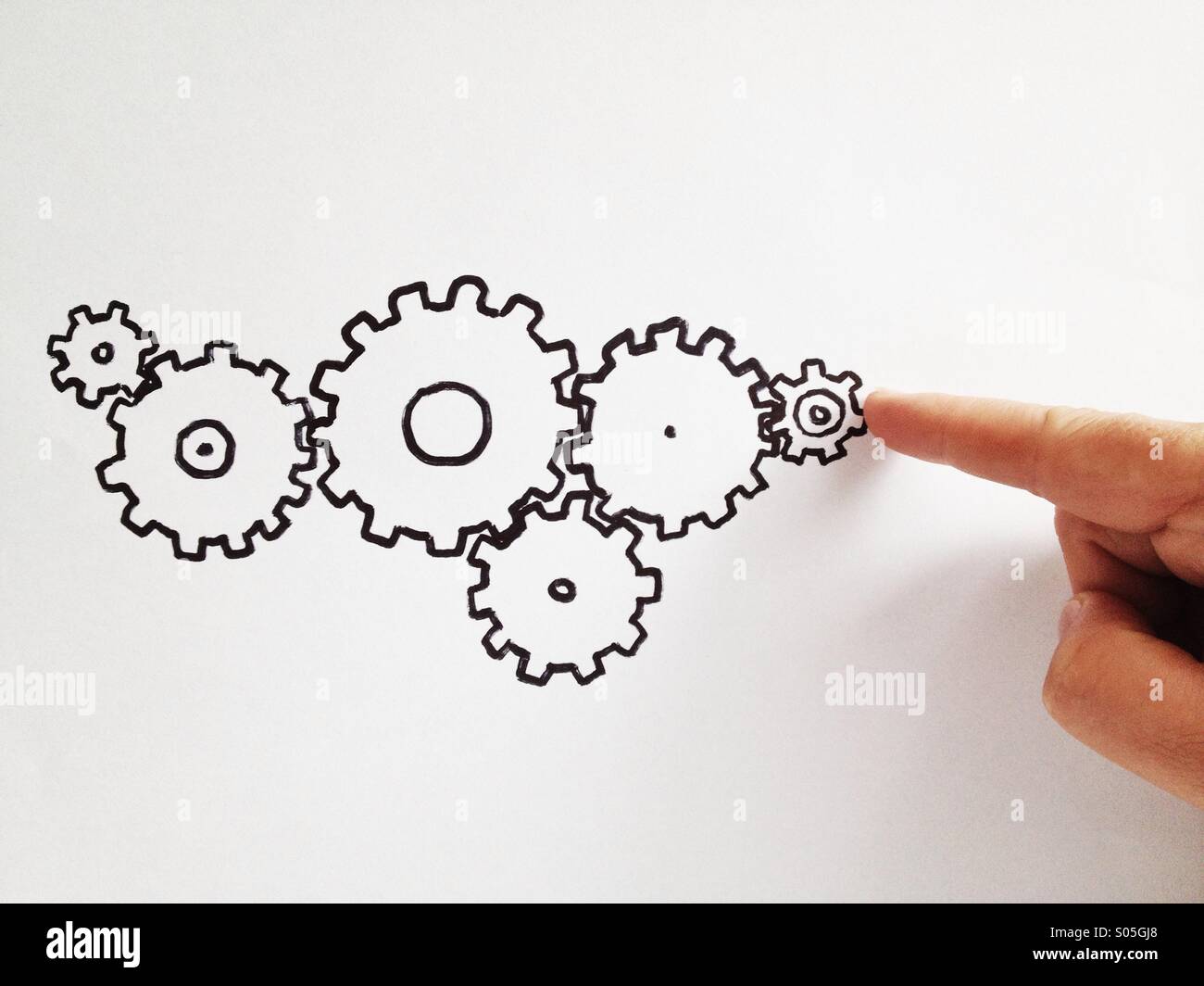 Finger moving gears Stock Photo - Alamy