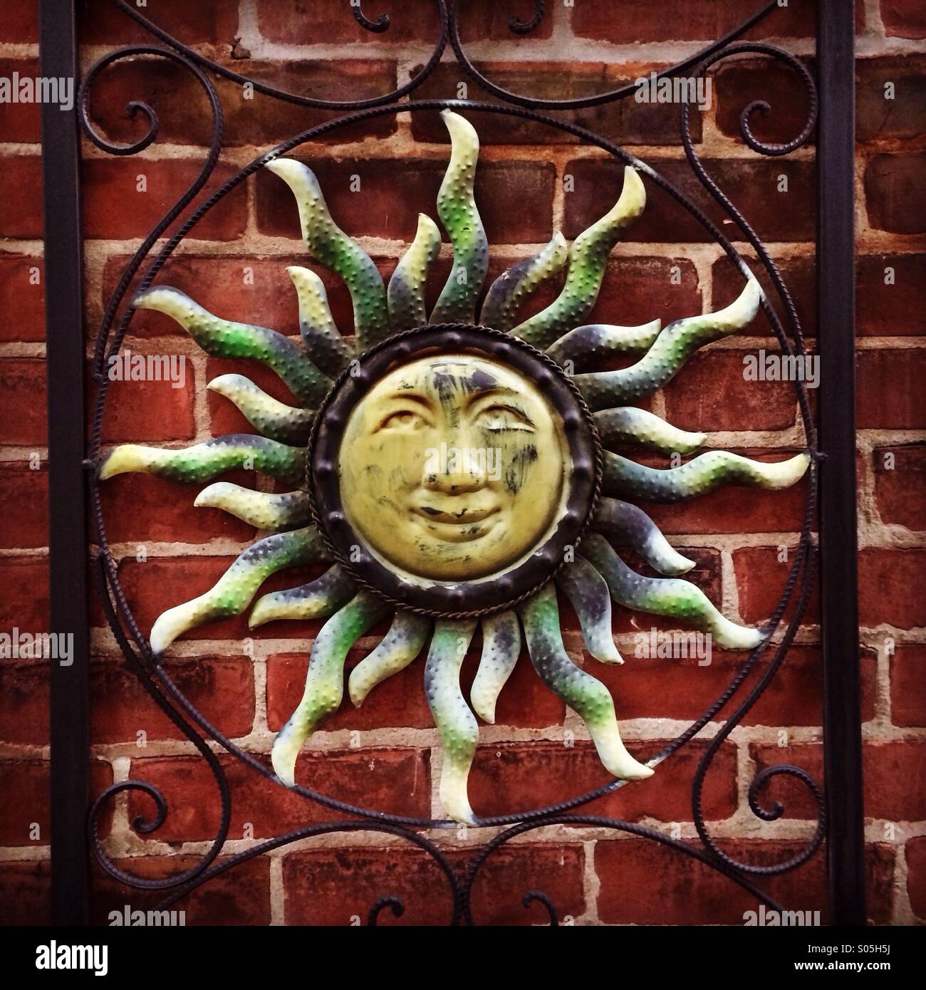 Ceramic sun face with brick wall Stock Photo - Alamy