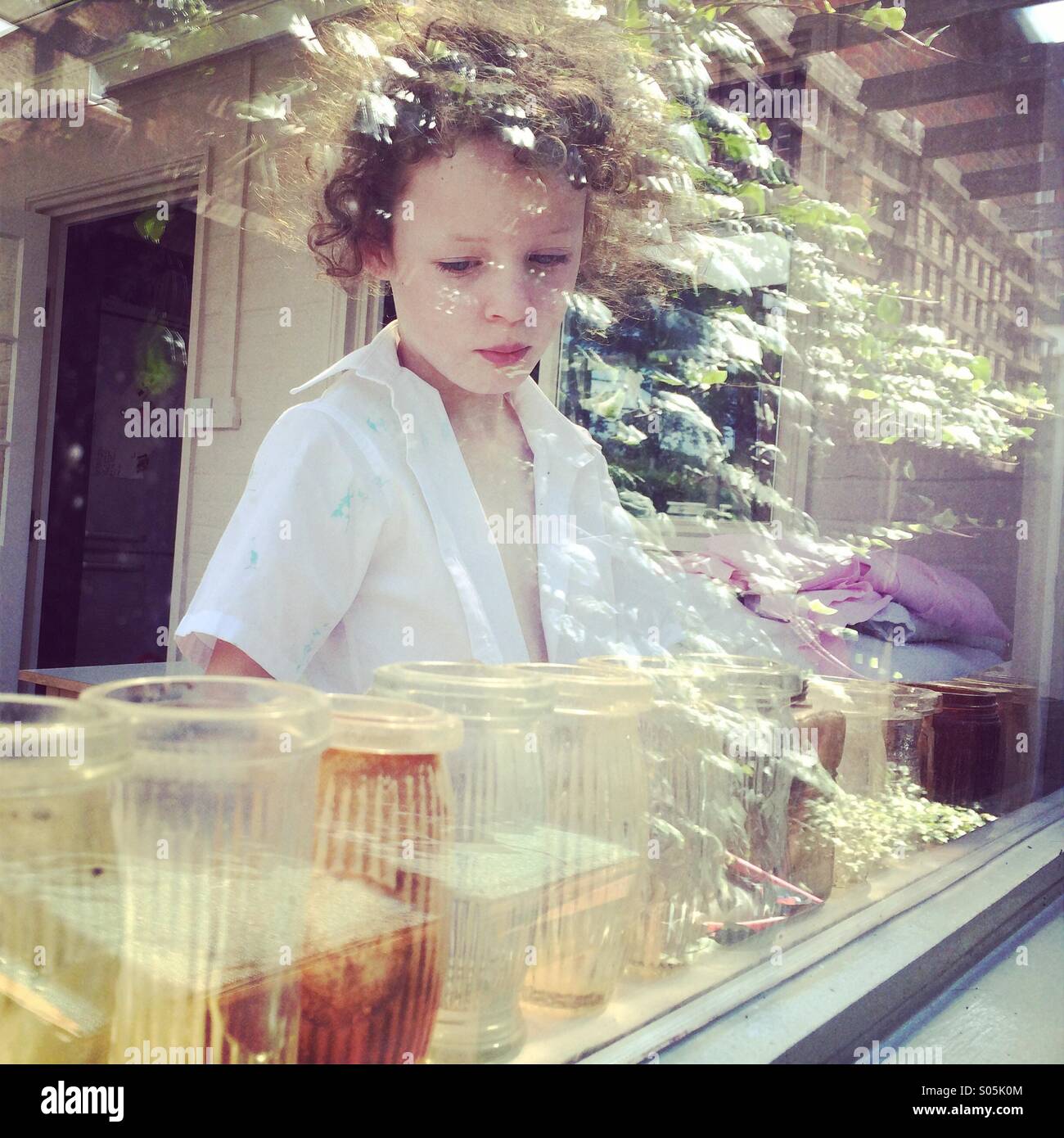 Thoughtful girl behind window with reflections Stock Photo - Alamy