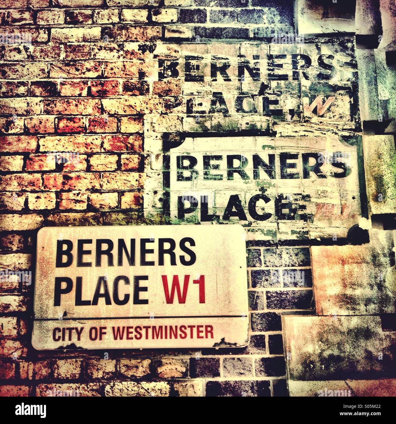 Three road signs for the same road, two faded out on a brick wall Stock ...