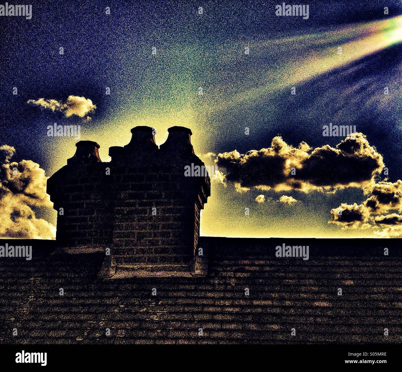 Chimneys on rooftop with clouds and suns rays in background Stock Photo ...