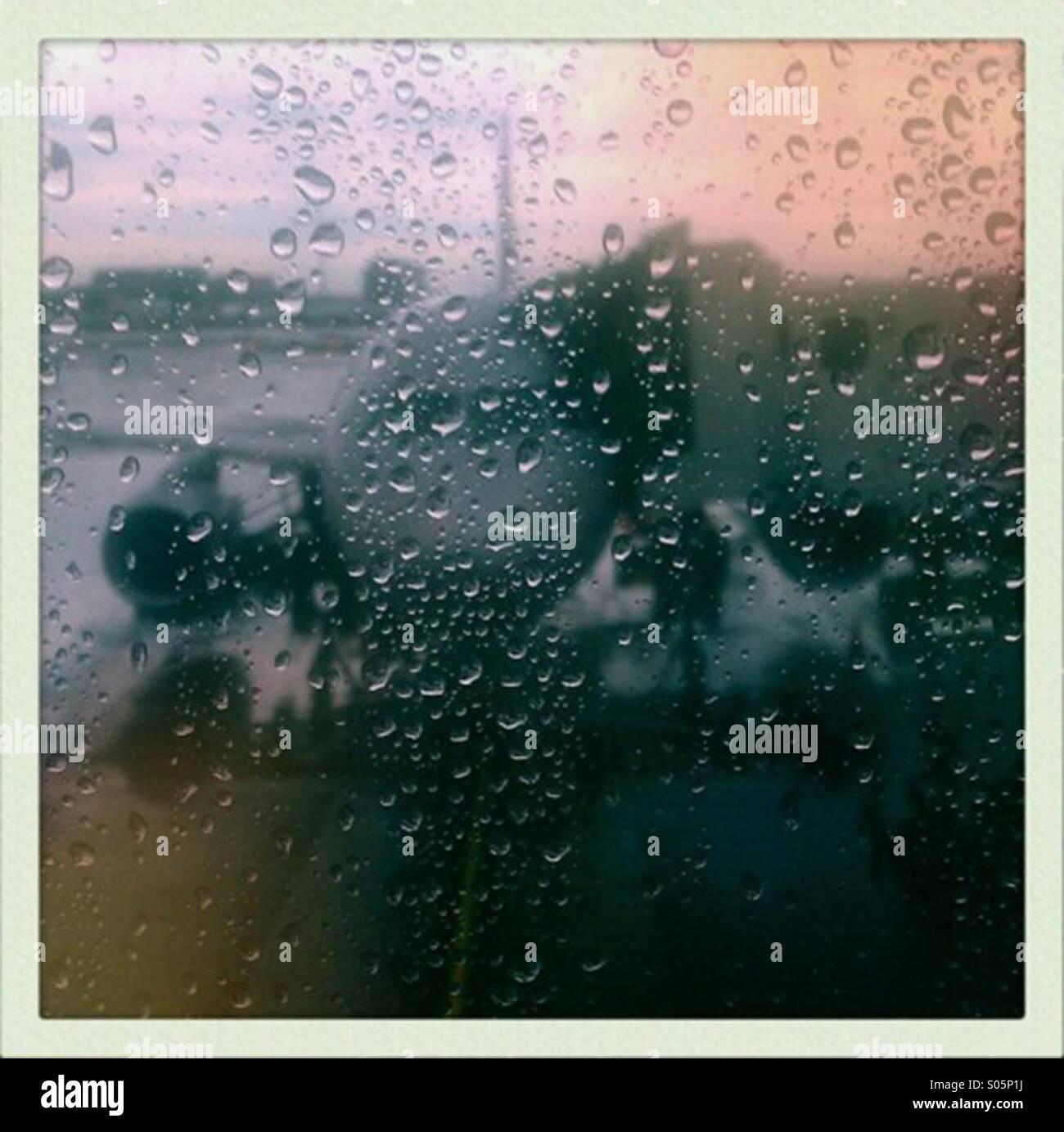 View of a plane at an airport through a rain covered window Stock Photo ...