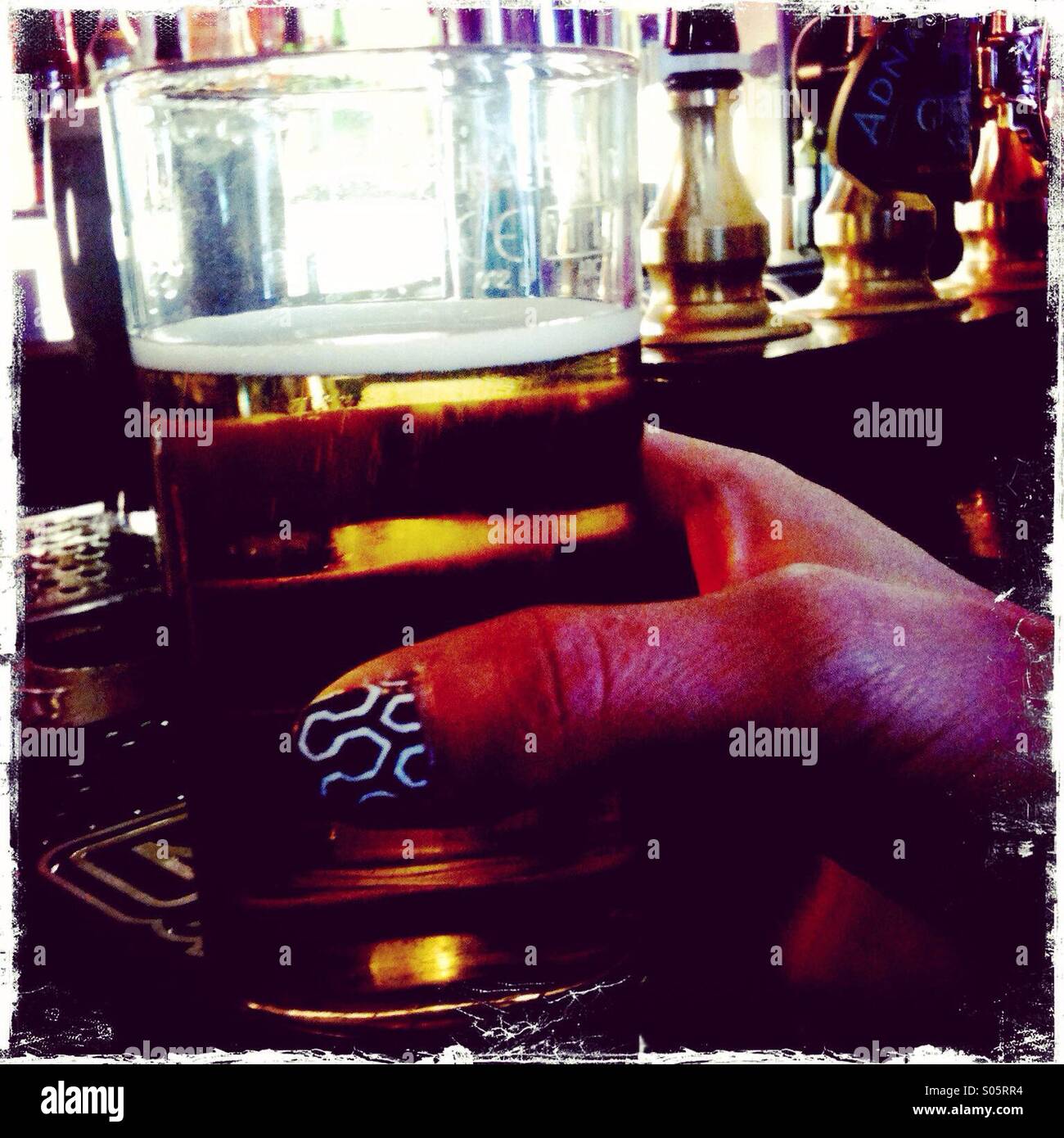Hand holding pint hi-res stock photography and images - Alamy