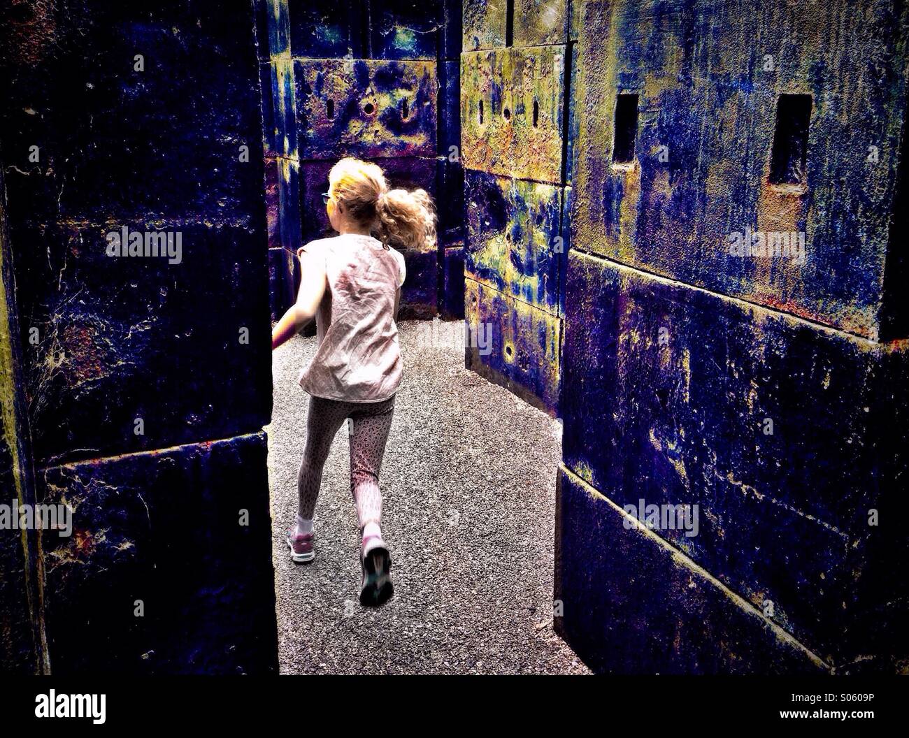 Girl running through maze Stock Photo - Alamy