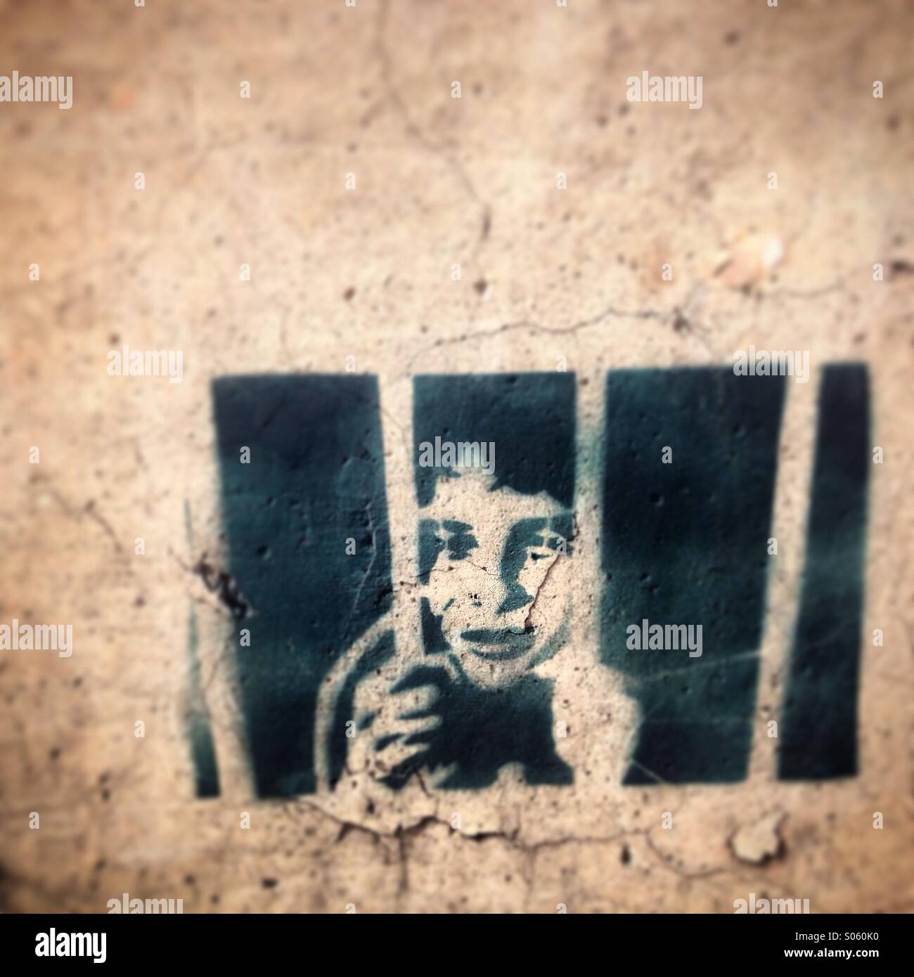 A graffiti of a boy in a prison decorates a wall in Merida, Yucatan ...
