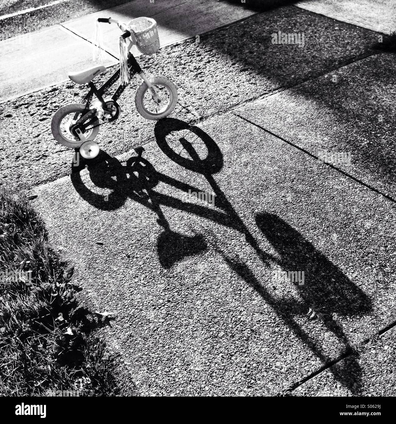 Bicycle on sidewalk with shadow Stock Photo - Alamy
