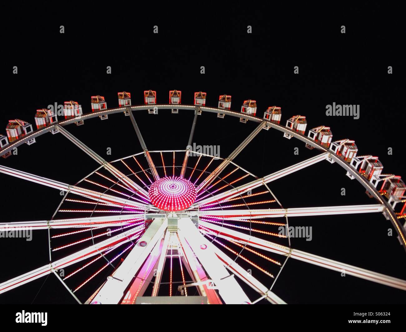 Illuminated ferris wheel at night at Hamburger DOM fun fair, Hamburg ...