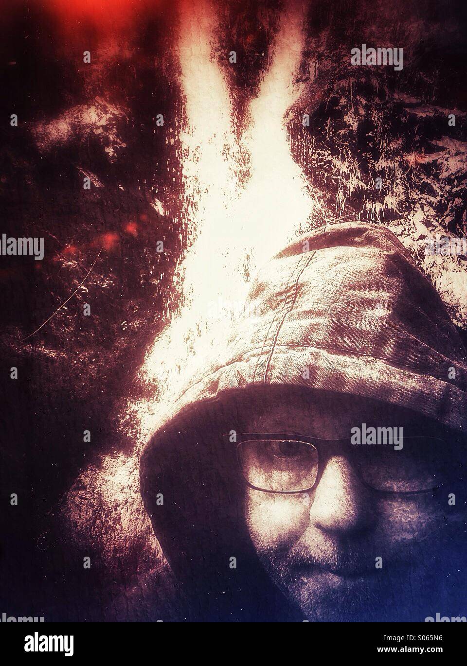 Man with a hood over his head in front of a waterfall Stock Photo - Alamy