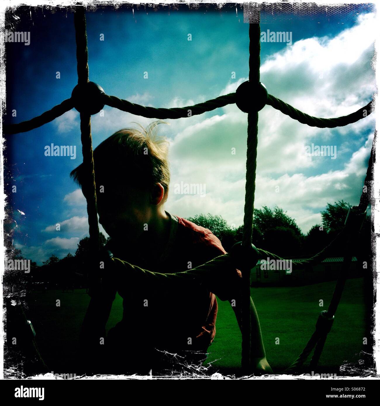 Boy climbing a rope net climbing frame Stock Photo - Alamy