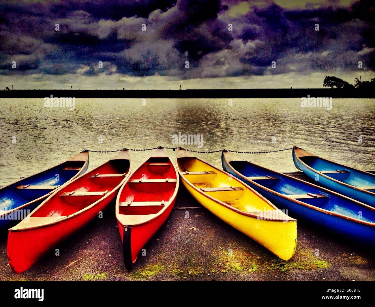 Colourful canoes on lakeside Stock Photo - Alamy