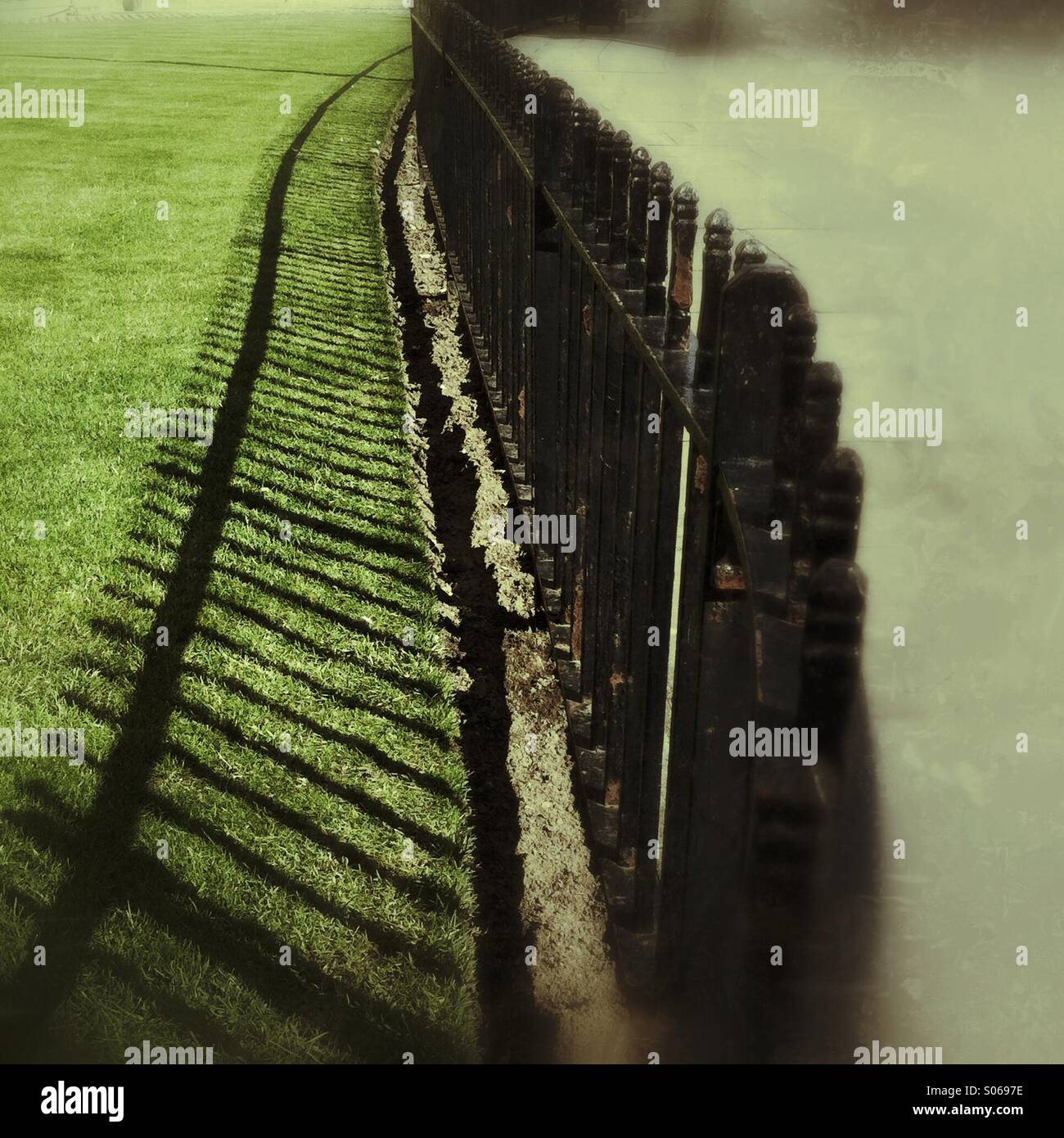 Shadow of Iron railings on grass Stock Photo - Alamy