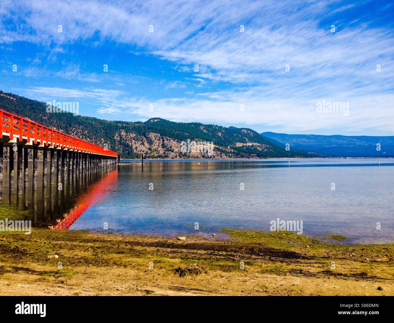 Red pier stretching out into the lake on a late summer day, in Chase ...