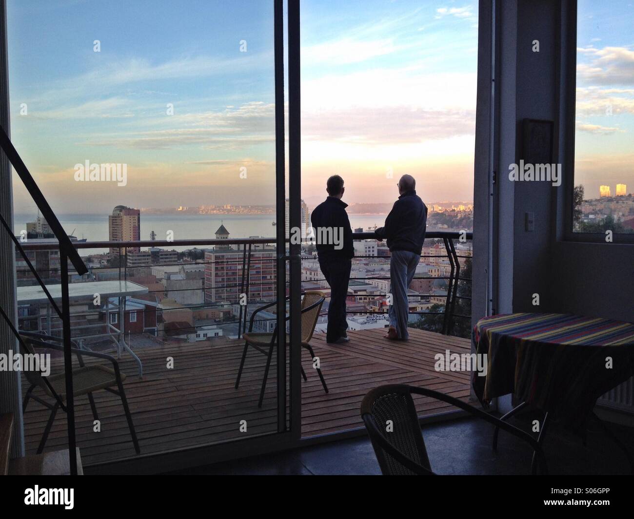 Couple looking over balcony in apartment, Valparaiso, Chile, South ...
