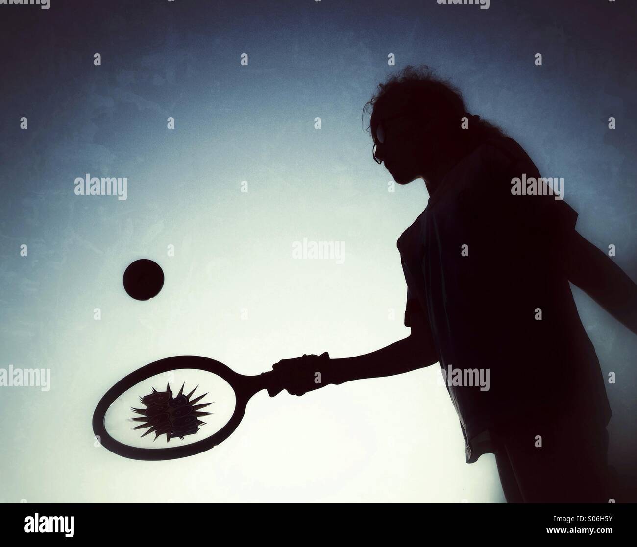 Girl bouncing ball on racket in silhouette Stock Photo - Alamy