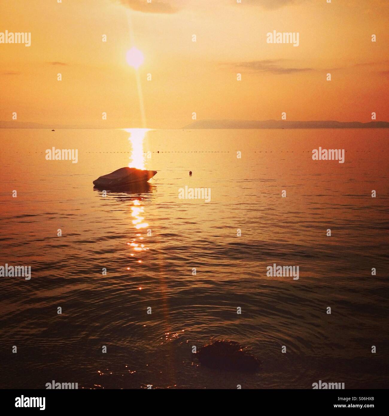 Sunset at sea with silhouette of speed boat Stock Photo - Alamy