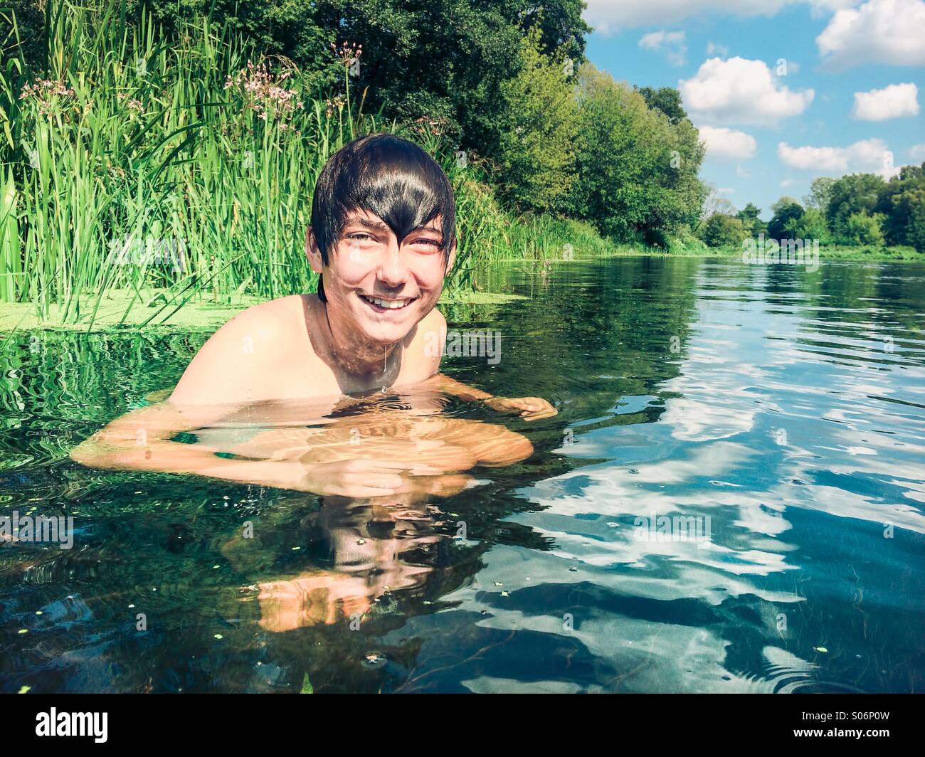 Young boy splashing in the river Stock Photo - Alamy