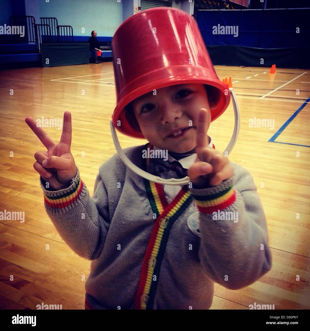 Little eurasian boy with red bucket on the head Stock Photo - Alamy