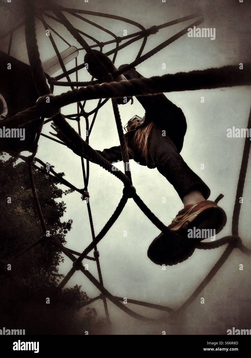 Girl climbing rope climbing frame Stock Photo - Alamy
