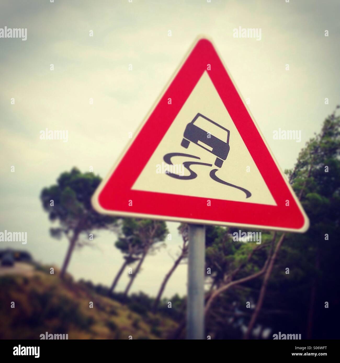 Slippery road traffic sign with forest in background Stock Photo - Alamy