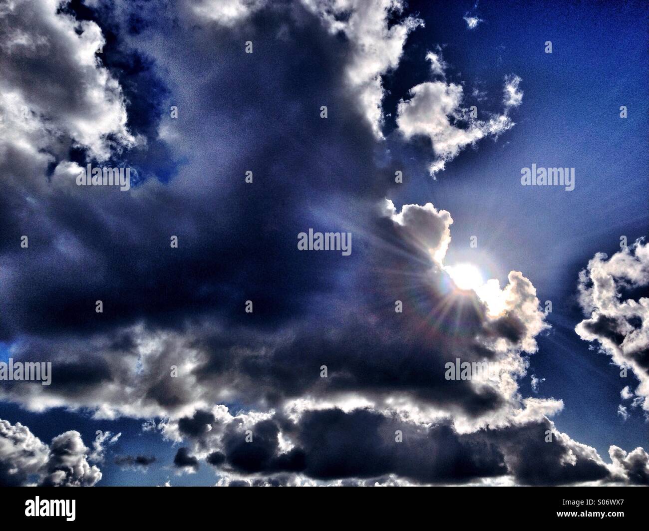 Sun breaking through dark clouds Stock Photo - Alamy