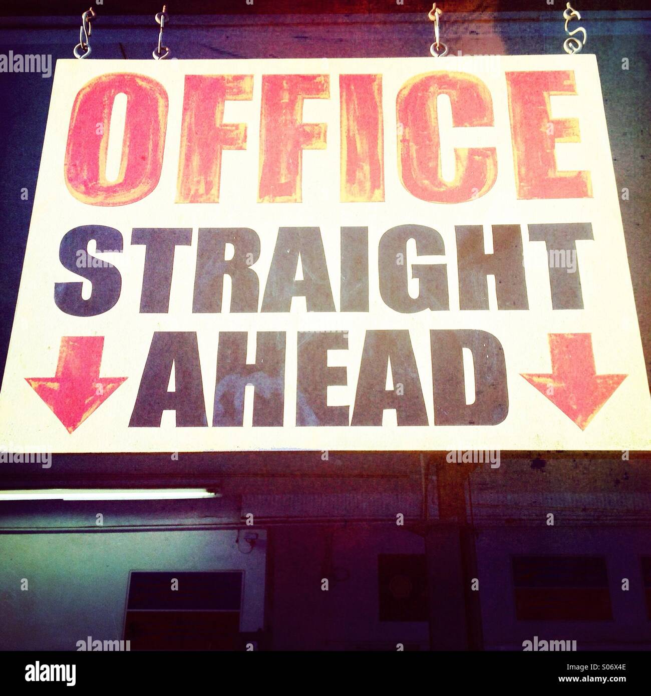 A sign giving directions to the office straight ahead Stock Photo - Alamy