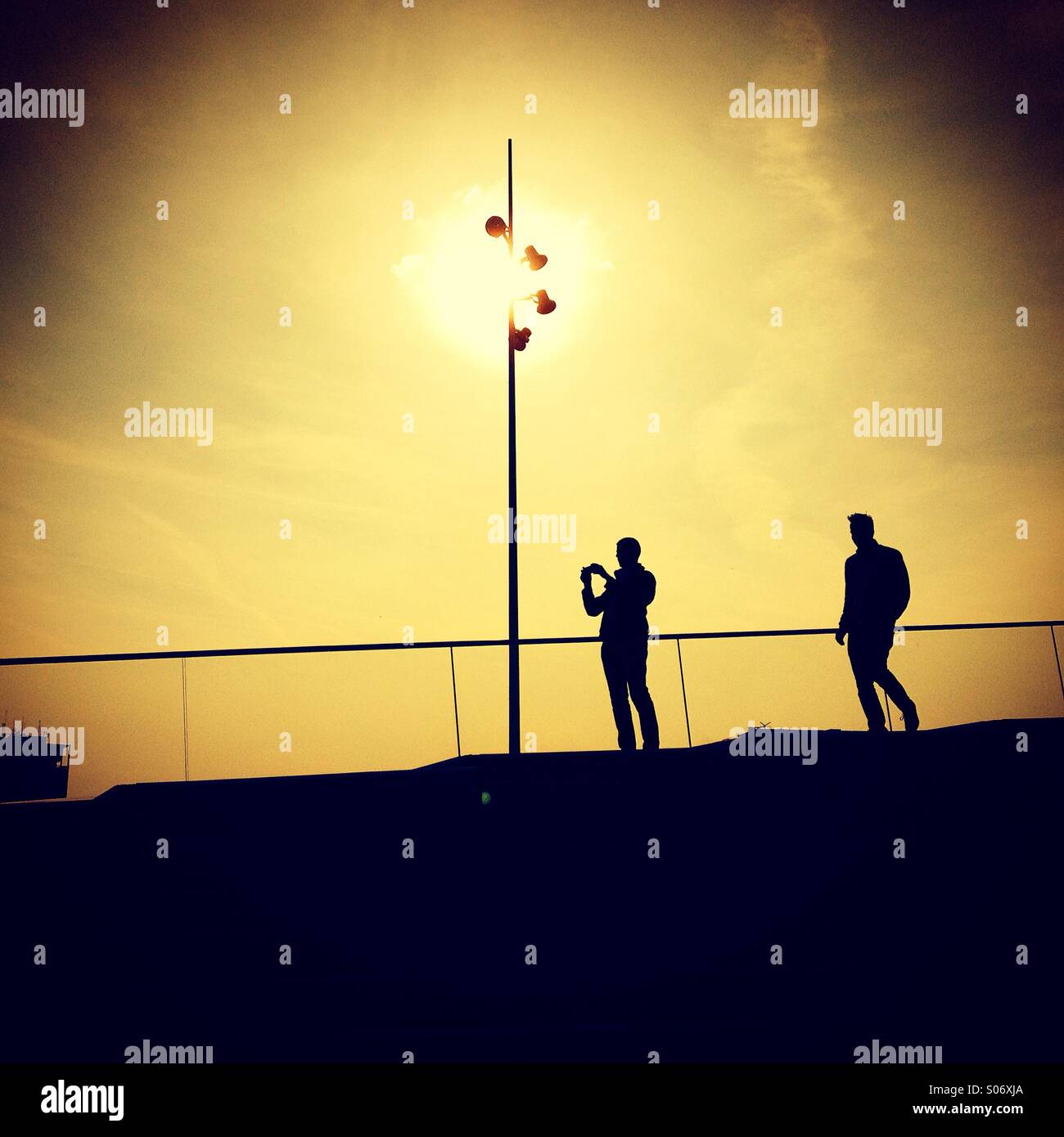 Silhouette of two men at sunset Stock Photo - Alamy