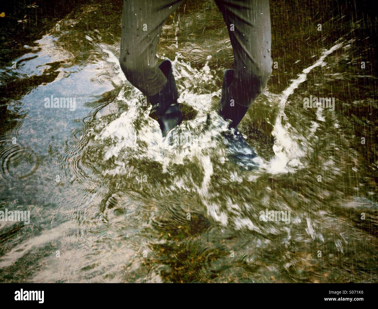 Child Splashing in stream in rain Stock Photo - Alamy