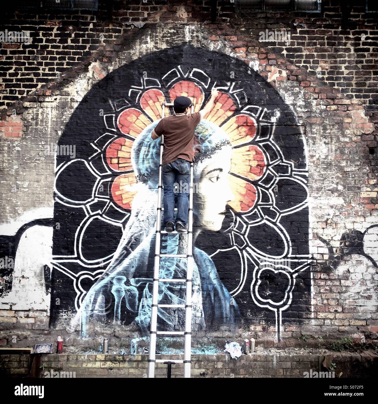 A street artist painting a mural in Sheffield UK Stock Photo - Alamy