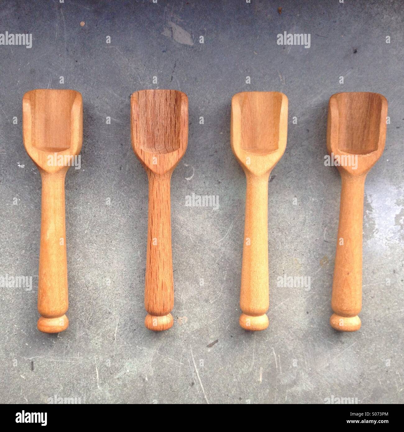 Four wooden spoons on a grey background Stock Photo - Alamy