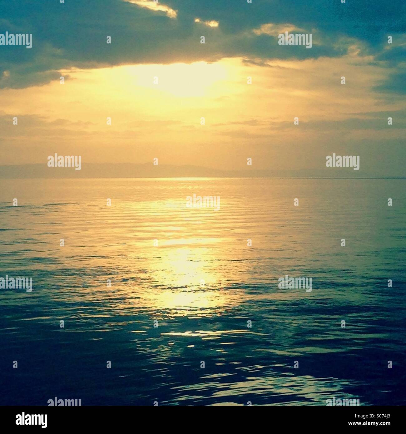 Sunset at sea with sun reflection Stock Photo - Alamy