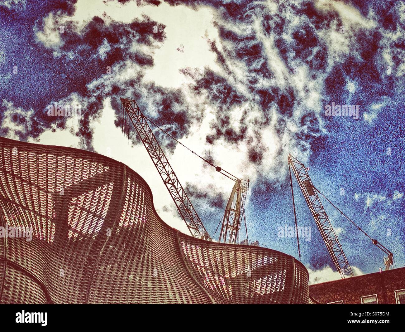 Wicker structure with cranes in the background Stock Photo - Alamy