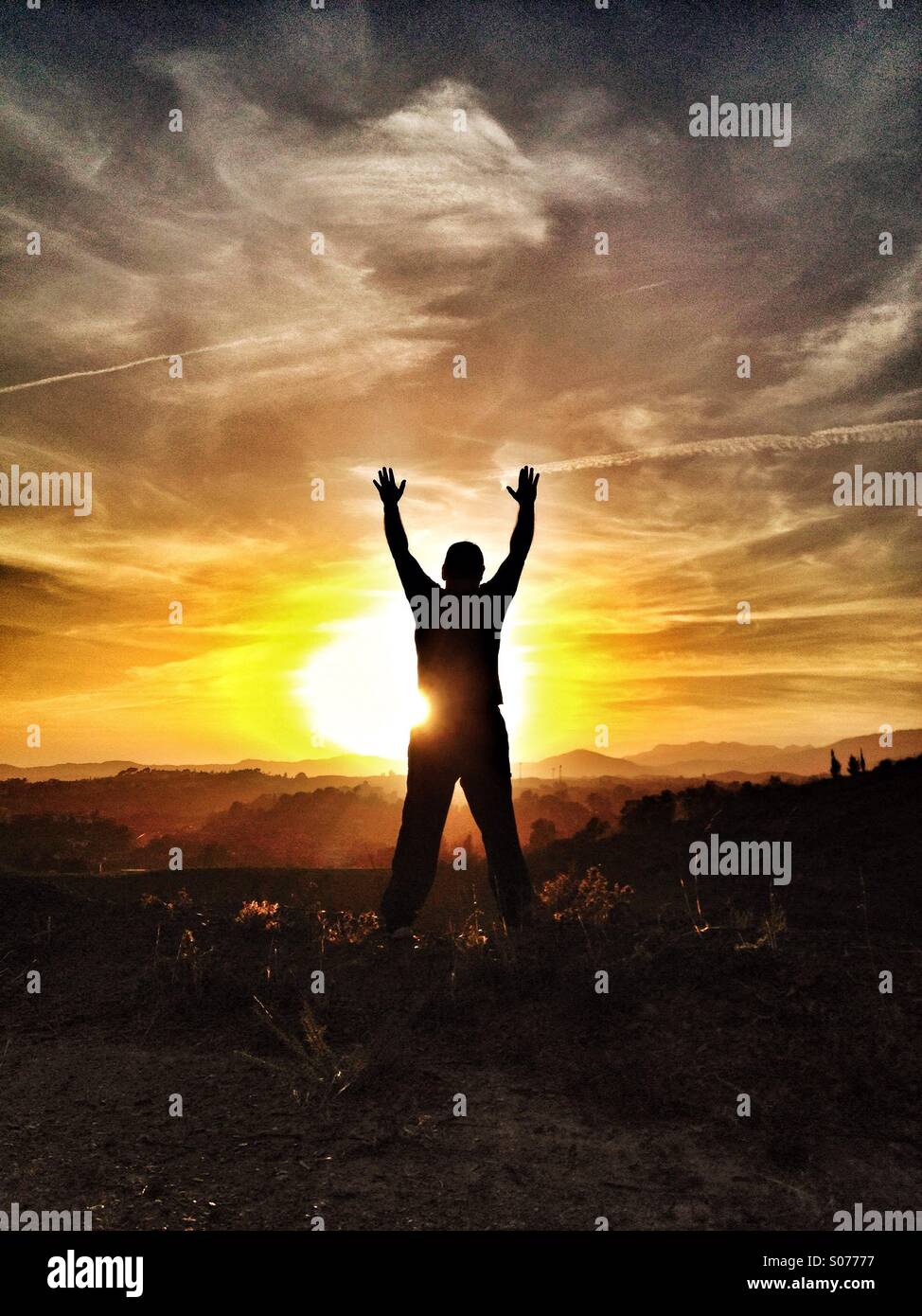 Silhouetted figure of man at sunset Stock Photo - Alamy