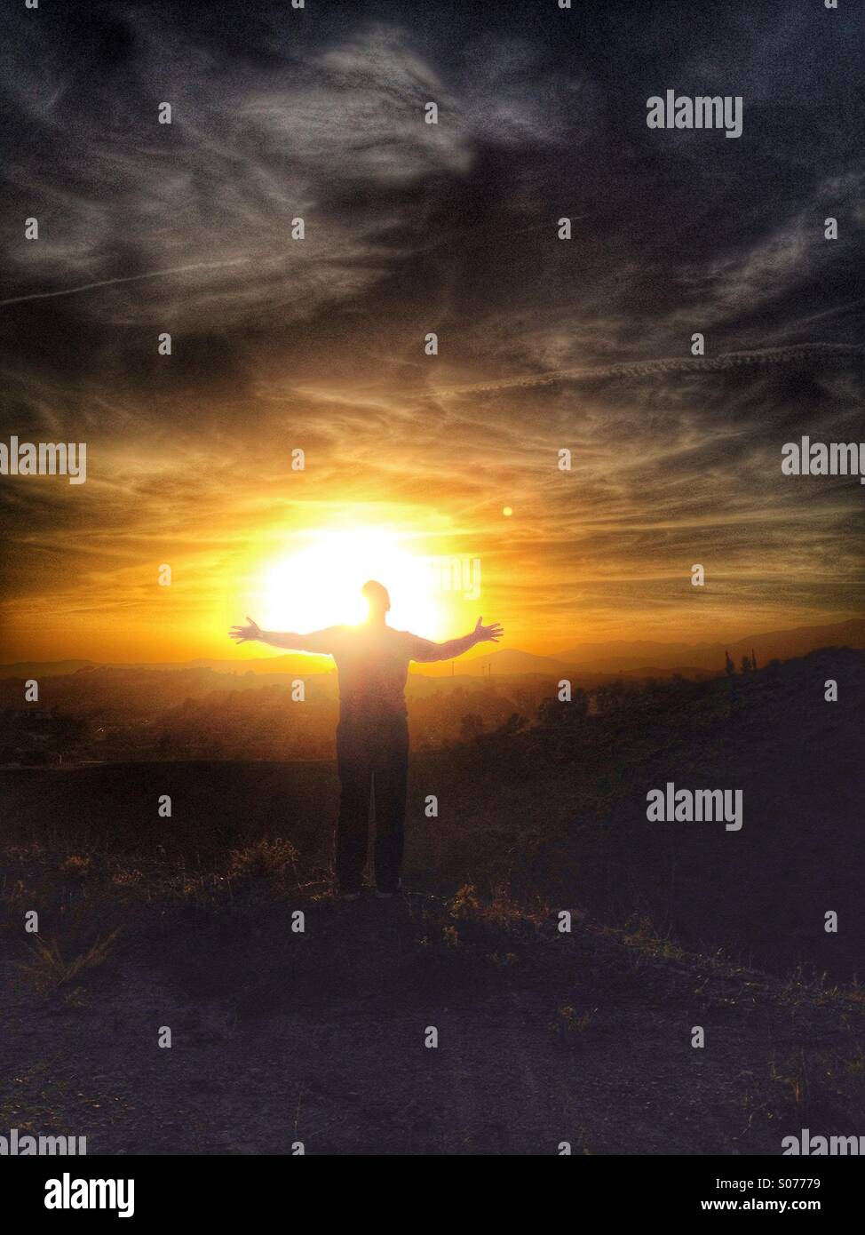 Silhouetted figure of man at sunset Stock Photo - Alamy