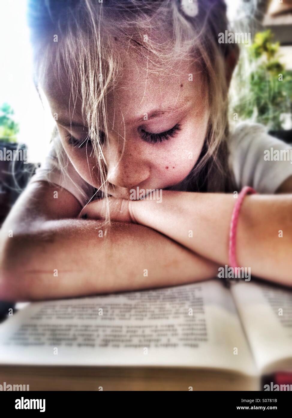 Little girl reading a book Stock Photo - Alamy