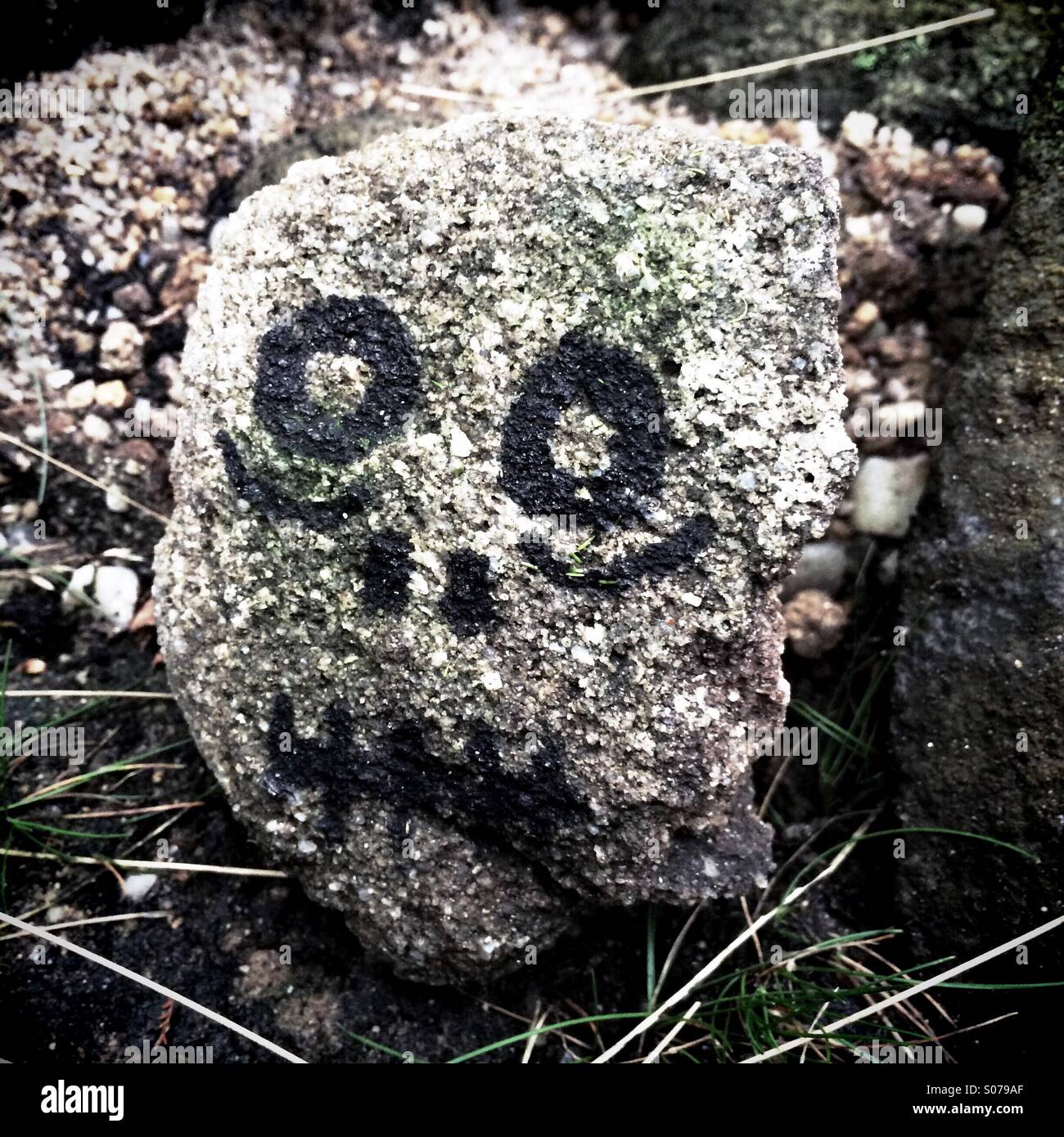 A scary face drawing on a rock Stock Photo - Alamy