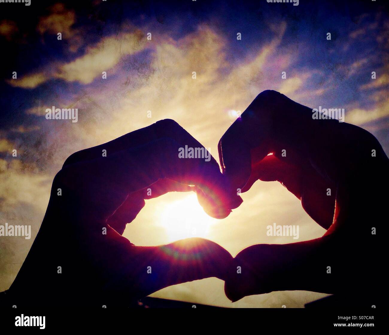 Child's hands forming heart shape against sun Stock Photo - Alamy