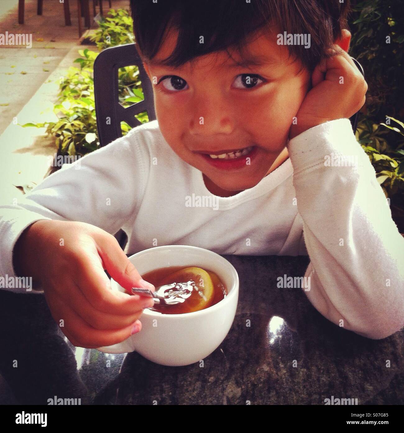 Little cheeky boy is having a lemon tea Stock Photo - Alamy