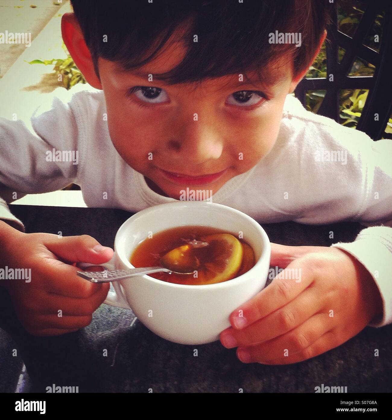 Little child having a cup of lemon tea in a cup Stock Photo - Alamy