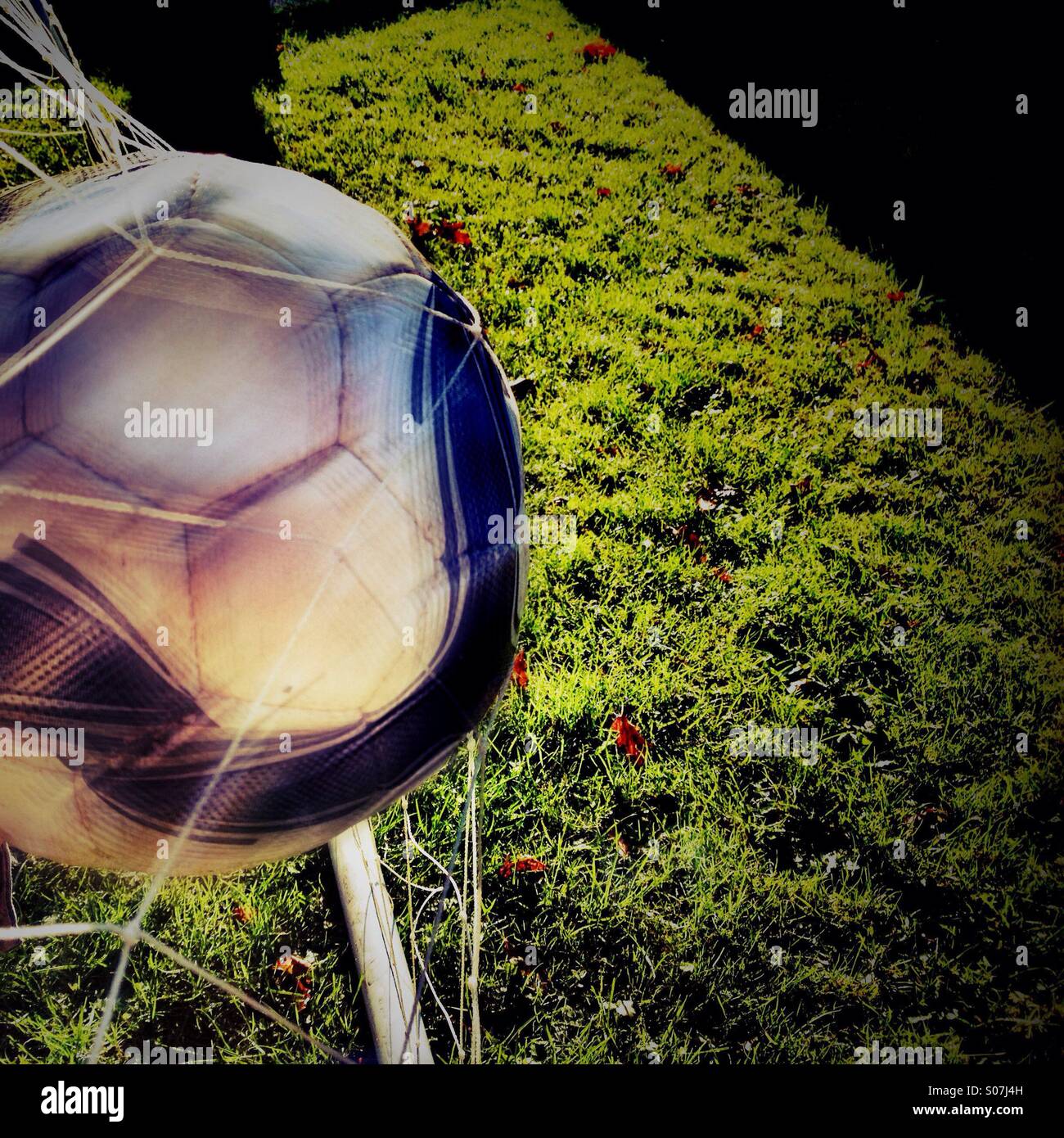 Blurred football hitting back of net Stock Photo - Alamy