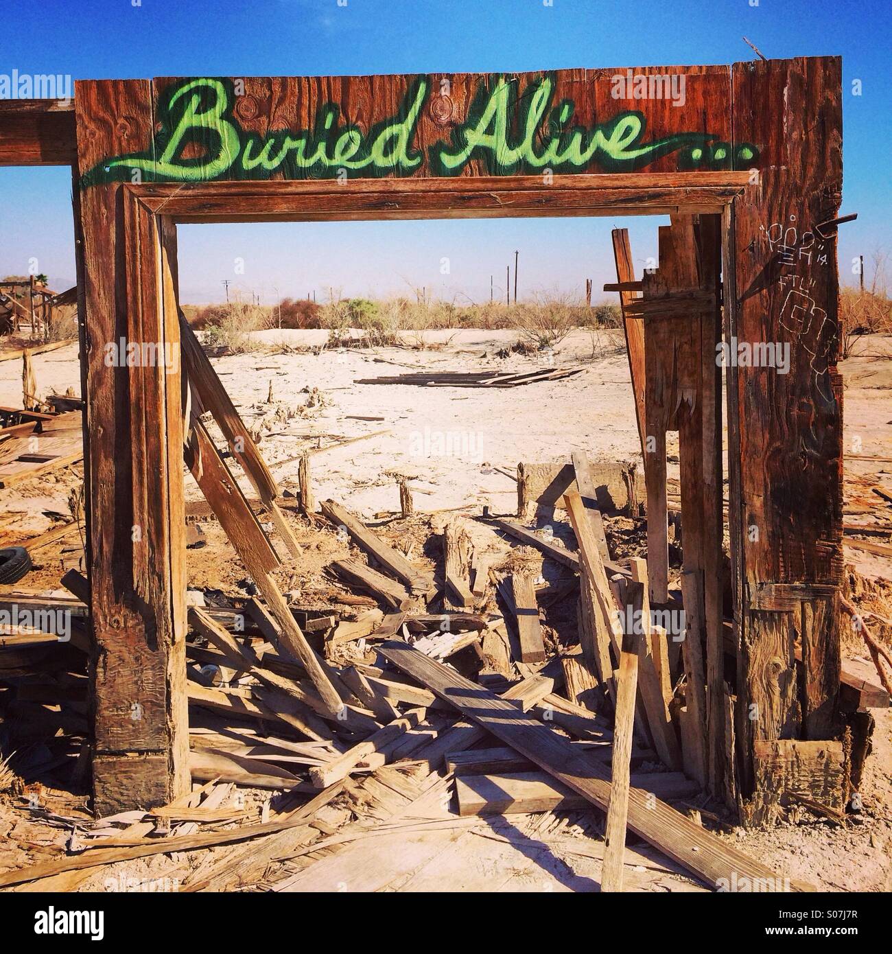 Buried alive sign on destroyed home Stock Photo - Alamy